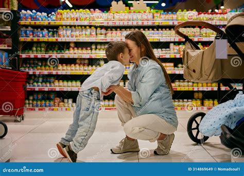 Portrait Of Happy Excited Pregnant Mom And Son Fooling Around In Store