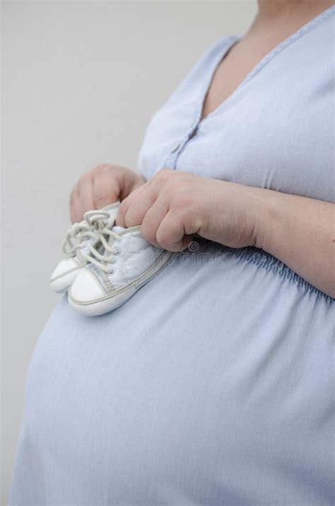 Pregnant Woman In Light Blue Denim Dress Holding Pacifier Stock Photo Image Of Denim