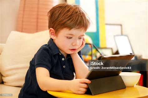 가정에서 침대에 태블릿 Pc를 사용 하는 아이 소파에 귀여운 소년은 만화를 보고 게임을 재생 하 고 노트북에서 학습 교육 재미 레저 행복 현대 컴퓨터 기술 및 통신 교육에