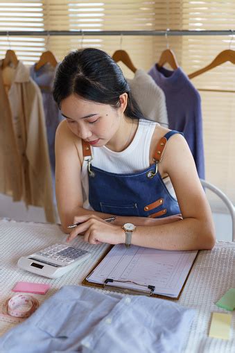 젊은 아시아 온라인 상인 여성은 계산기를 사용하여 온라인 쇼핑 주문을 확인하고 계산하면서 온라인 쇼핑 배송 배송 및 고객 배송 준비에 대해 작업합니다 20 24세에 대한