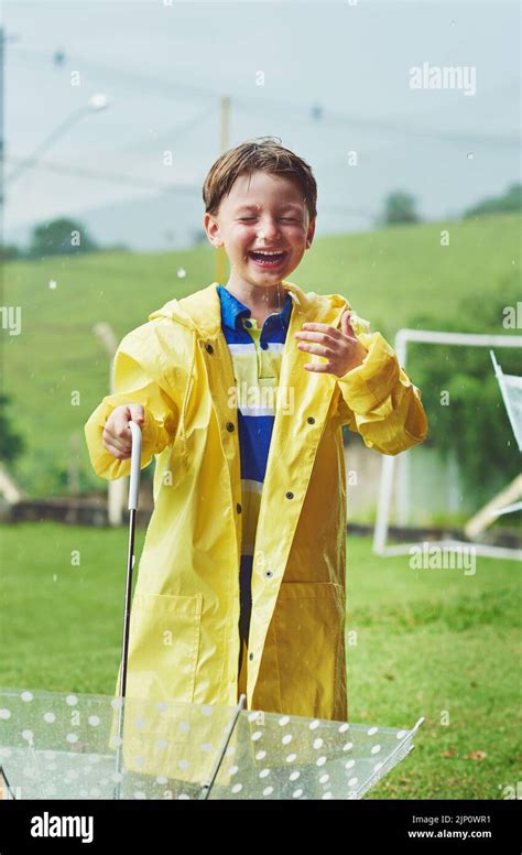 The Rain Doesnt Bother Him A Cheerful Little Boy Standing With An