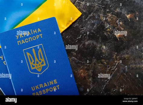 Ukrainian Biometric Passport And Ukrainian Flag On A Dark Background