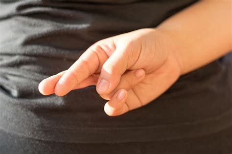 4 월 바보의 날 그녀의 뒤에 여자 아이 손 교차 하는 손가락의 클로즈업 소녀 아이의 검지 손가락과 가운데 손가락이 서로 교차