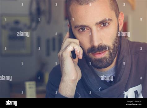 Portrait Of A Young Man With Beard Talking On His Cell Phone Stock