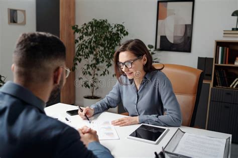 Smiling Woman Pointing At Data Report During Meeting Stock Image