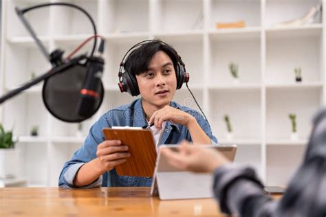 Man And Woman Podcasters Interview Each Other For Radio Podcast Stock