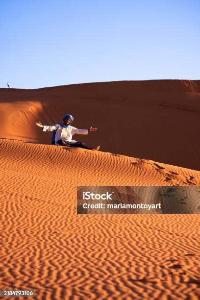 사막 모래 언덕 풍경에 앉아 두 팔을 벌리고 큰 미소를 짓는 투아레그 에르그 체비 메르주가 사하라 사막 모로코 아프리카 30 34세에 대한 스톡 사진 및 기타 이미지