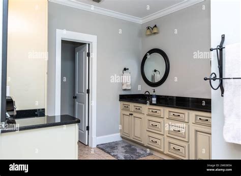 A Double Bathroom Vanity With Black Granite Counter Tops And Cream