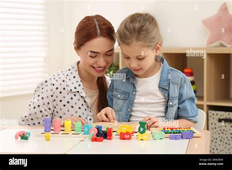 Happy Mother And Daughter Playing With Different Math Game Kits At Desk