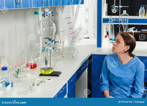 Il Giovane Scienziato Femminile In Uniforme Esamina Le Boccette Dopo La