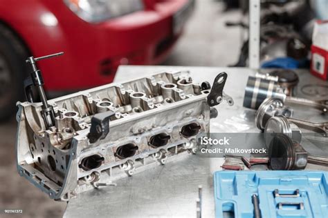 선택적 초점입니다 엔진 블록 수리에 피스톤 및 커넥팅 로드의 자동차 기술로 서 배경에 흐린된 빨간색 자동차입니다 자동차 수리가 게의 인테리어입니다 가솔린에 대한 스톡 사진