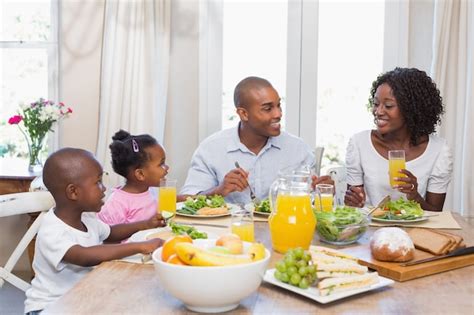 Familia Feliz Disfrutando De Una Comida Saludable Juntos Foto Premium