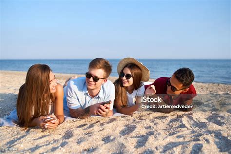 Millenials의 젊은 민족 그룹 하얀 모래에 바다 근처 비치 타월에서 휴식 멋진 친구 들이 해변에서 놀고 이야기 하 고