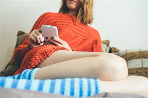화려한 양말 침대에 앉아서 휴대 전화를 사용 하 여 여자입니다 20 29세에 대한 스톡 사진 및 기타 이미지 20 29세