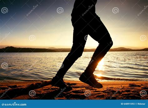 Silhueta Do Homem Ativo Do Esporte Que Corre E Que Exercita Na Praia No