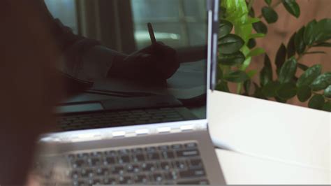 클로즈업 노트북 화면에서 반사 책상에서 노트북을 사용 하는 동안 뭔가를 쓰고 비즈니스 여자의 손의 자른 샷 사업 여자 가제트와 함께 작업 사무실에서 문서 경영자에 대한 스톡