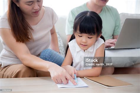 어머니가 숙제를 가르치는 행복한 가족 딸과 아버지가 집 거실 소파에서 노트북으로 일하는 모습 엄마가 아이와 함께 학업 라이프