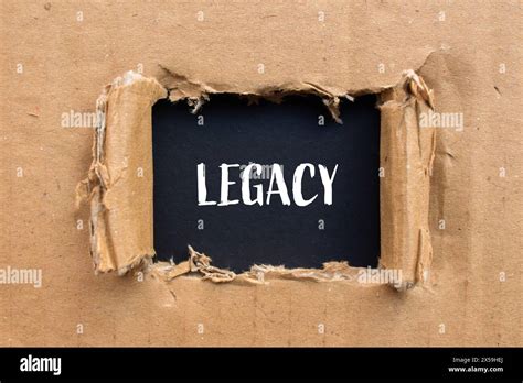 Legacy Word Written On Ripped Cardboard Paper With Black Background