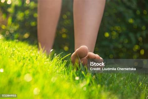Teenage Girl Walking Barefoot On Green Grass Outdoors Closeup Space For