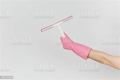 핑크 장갑 가로 흰색 배경에 고립 된 빨간 요소와 함께 표면 청소를 위해 백색 고무 롤러를 보유 하 고 있는 여성 손의 닫습니다