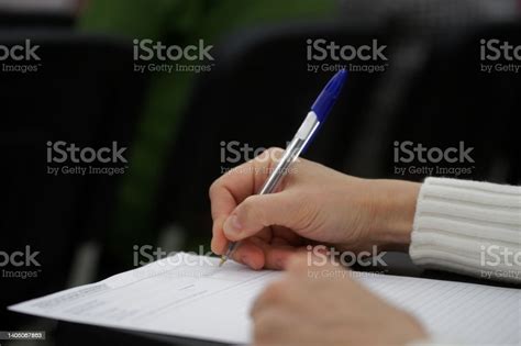 파란색 만년필을 가진 여성이 인쇄 된 양식 계약서 또는 이력서를 작성합니다 얼굴이 없습니다 선택적 초점 만년필에 대한 스톡 사진