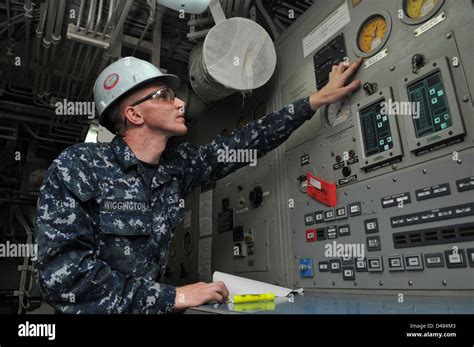 A Sailor Inspects Steam Gauges Aboard A Vessel At Naval Base Kitsap