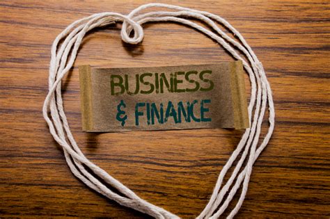 개념적 손을 쓰기 텍스트 캡션 비즈니스 및 금융입니다 어두운 나무 배경에 스티커 메모 용지에 작성 하는 회사 전략에 대 한 비즈니스 개념 심장 의미 사랑 또는 숭배 개념에