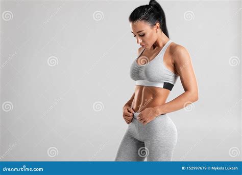 Fitness Woman Showing Abs And Flat Belly Isolated On Gray Background