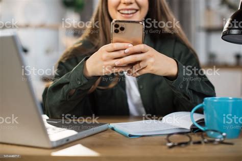 테이블에 앉아서 스마트 폰이있는 현대 노트북을 사용하는 여성 고용주의 잘린 전망 20 24세에 대한 스톡 사진 및 기타 이미지 20 24세 Brand Name