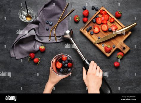 Female Hands Berries Wooden Tray Napkin And Blender On Black