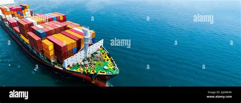 Aerial Side View Of Cargo Ship Carrying Container And Running For