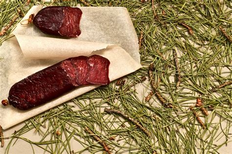 알 사슴 고기로 만든 말린 소시지 양피지 큰 조각에 조각으로 잘라 소나무 바늘로 만든 바닥 가공육에 대한 스톡 사진 및 기타 이미지 Istock