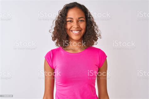분홍색 티셔츠를 입은 젊은 브라질 여성이 얼굴에 행복하고 시원한 미소를 지으며 고립 된 흰색 배경 위에 서 있습니다 운이 좋은
