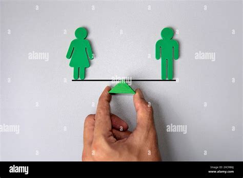 Hand Holding Wooden Triangle With Male And Female Human Figure On