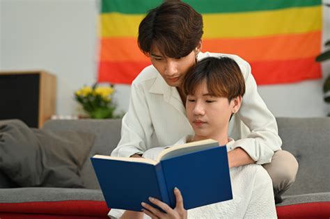 행복한 게이 커플은 집에서 소파에 앉아 책을 읽고 주말에 함께 시간을 보낸다 Lgbtq 사람들의 라이프 스타일과 사랑 감정 20
