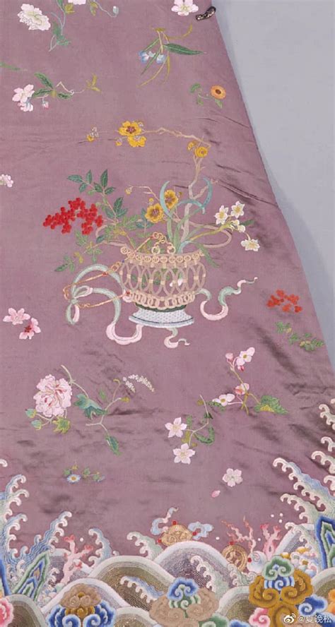 清 乾隆 雪灰色缎绣四季花卉花篮纹夹袍 这是乾隆朝后妃的吉服，非常温柔的一件吉服袍。上面以花篮配飘带构成团花图案，间以折枝花卉的纹样。 花朵刺绣极其逼真，有百合、萱草、木绣球、牡丹、海棠