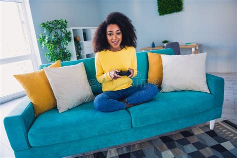 Photo Of Cheerful Positive Girl Sitting On Sofa Playing Video Game