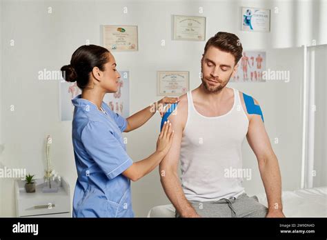 Handsome Man In Casual Attire Sitting While His Young Doctor Putting