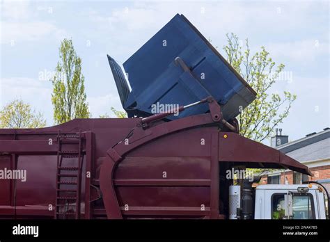 Waste Is Loaded Into Trash Bin By Municipal Sanitation Disposal Service