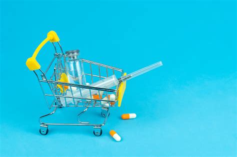 파란색 배경에 의료용 앰플 주사기 및 캡슐이 있는 쇼핑 카트 복사 공간 의약품 구매 약가 인상의 개념 약에 대한 스톡 사진 및 기타 이미지 Istock