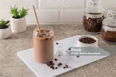 흰색 대리석 보드에 얼음 조각 항아리 형태로 현대 유리에 바닐라와 계피가 들어간 멋진 커피 회색 콘크리트 배경 커피 마실 것에