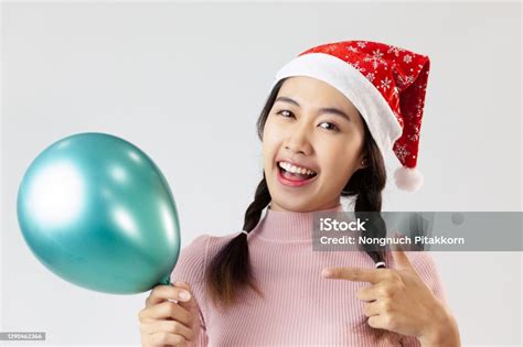 산타 모자를 쓰고 녹색 풍선을 들고 흰색 배경에 미소 짓는 아시아 여성 12월에 대한 스톡 사진 및 기타 이미지 12월