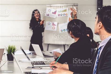 아시아 비즈니스 사람들은 국제 비즈니스 컨퍼런스에서 그룹 회의실 앞에 서 있는 사업가의 프레젠테이션을 듣고 다문화 기업 전략