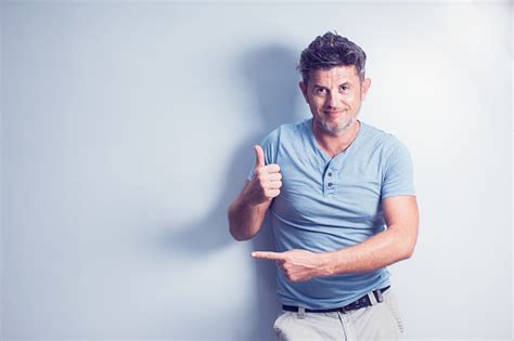 카메라 같은 표현의 및 승인 파란색 배경 위에 절연 제스처 엄지손가락 광범위 하 게 보여주는 미소는 중간 나이 남자 보여주기에 대한 스톡 사진 및 기타 이미지 Istock