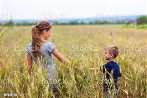 젊은 여성과 어린 소년은 밀밭에 서 있는 아들입니다 자연 개념과의 통일 가족에 대한 스톡 사진 및 기타 이미지 가족 귀여운