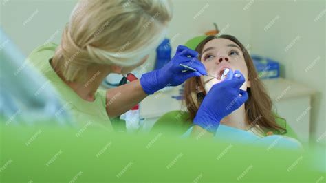 Premium Photo Dentist Putting Cotton Tampon Into Open Patient Mouth