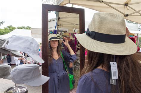 젊은 여 자가 모자에 시도 하 고 Eumundi 시장에서 거울을 보고 퀸즐랜드 호주 거울에 대한 스톡 사진 및 기타 이미지 거울 모자 모자류 반사 광학 작용 Istock