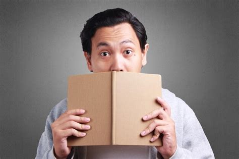 Premium Photo Young Man Holding Book Mouth Covered By Book