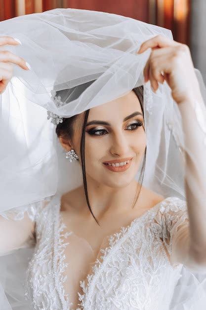 Premium Photo Beautiful Young Bride Holding Veil In White Wedding