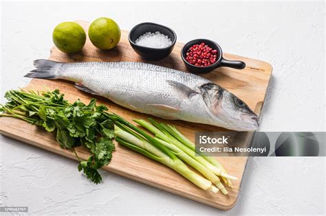 整個海低音與香料和草藥成分在切碎板上白色紋理背景側視圖空間的價格 照片檔及更多 俄羅斯 照片 俄羅斯 健康飲食 地中海餐 Istock